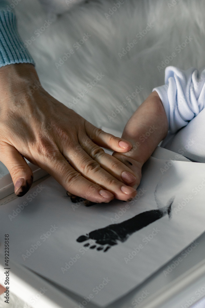 Baby footprints on white paper. Black footprint. The process of ...