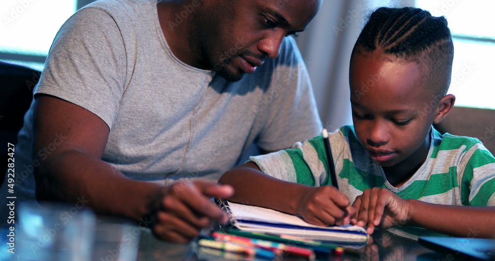 Little boy doing homework at home, African father helping son with ...