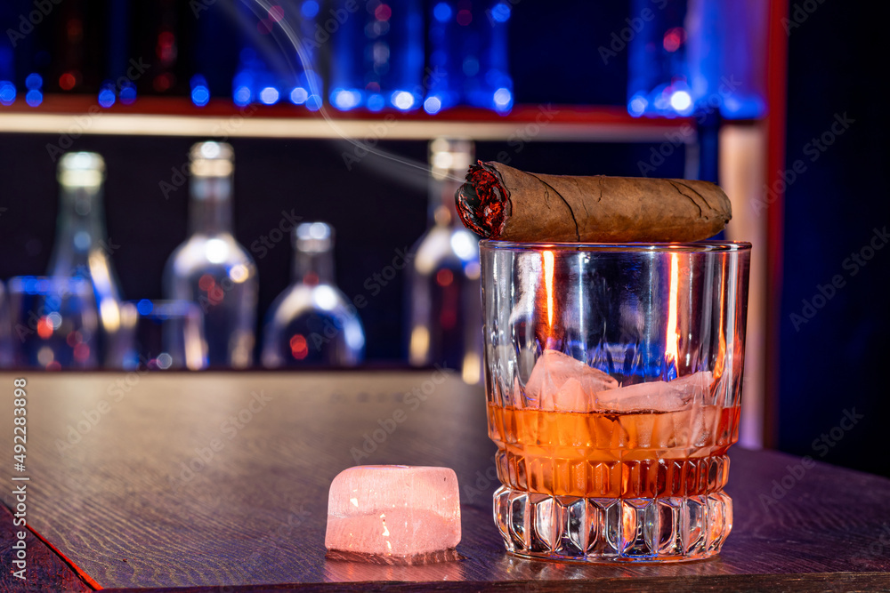 Cigar, elegant glass of brandy on the bar counter. Alcoholic drinks ...