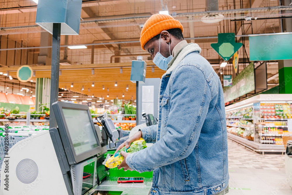 Foto de African-American man finger touches screen of self-pay point to ...