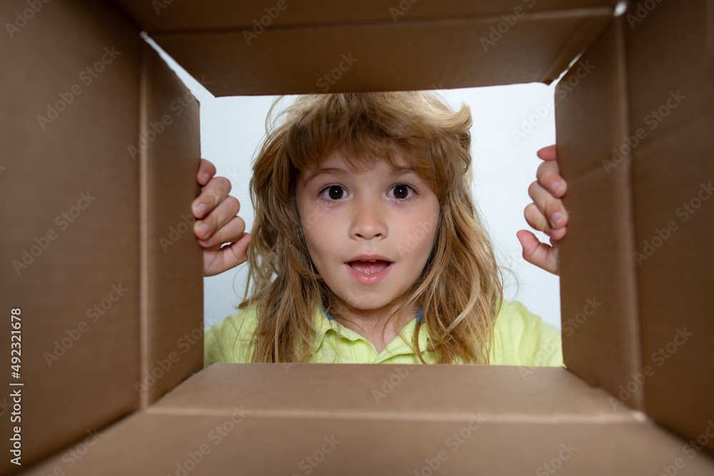 Surprised child boy age 7 year unpacking, opening carton box and ...