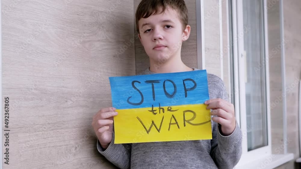 Child Holds in Hands a Poster with a Flag of Ukraine, and Message Stop ...
