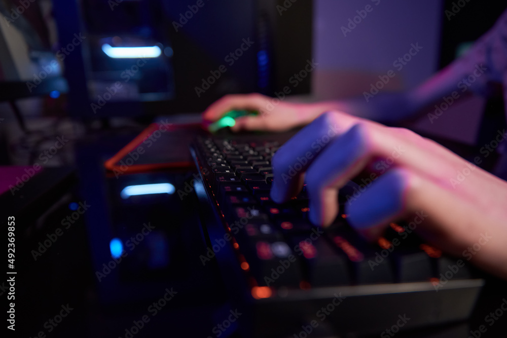 Professional gamer play computer video game in dark room, use neon ...