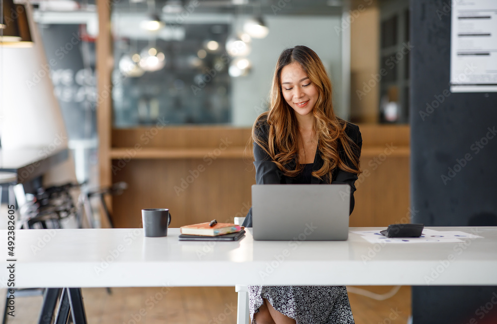 Charming Asian businesswoman sitting in the office with a digital ...