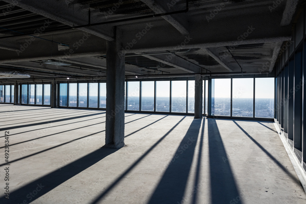 Moody and dramatic shadows from floor to ceiling windows in an empty ...