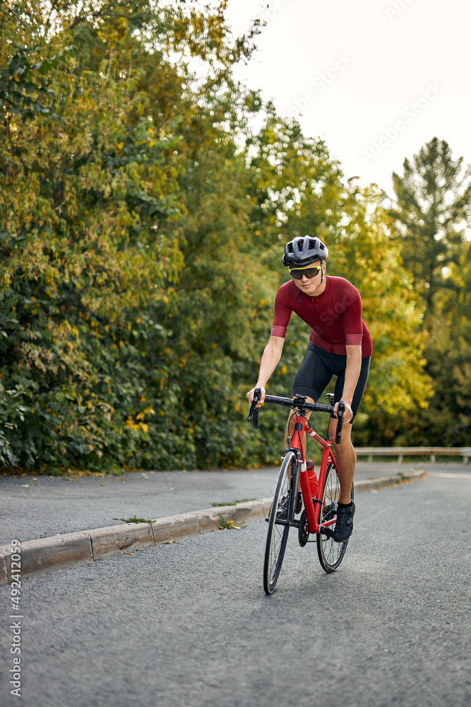 Handsome man biker in cycling clothing and protective helmet training ...