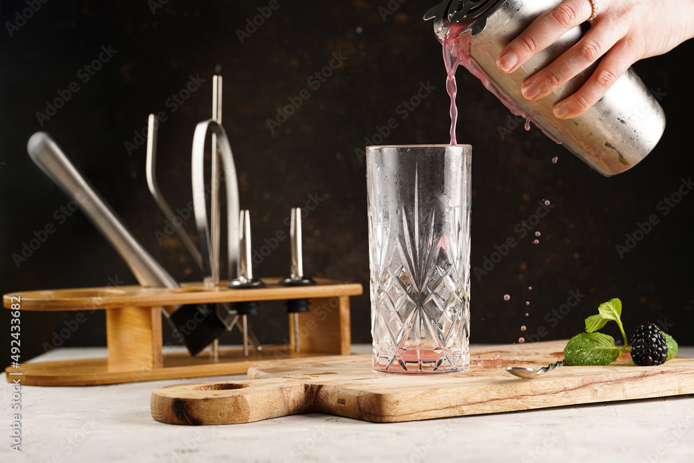Female bartender hand pouring non-alcoholic mocktail version of the ...