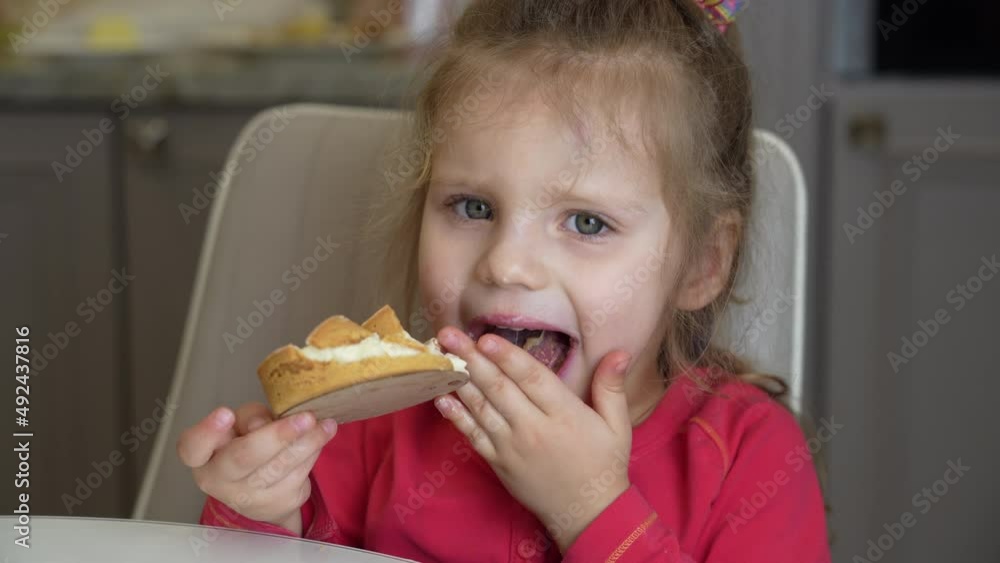 Adorable little girl eating fresh sweet raspberry cake indoors. Girl ...