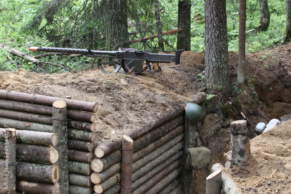 The position of the machine gunner in a wooden trench in the forest. A ...