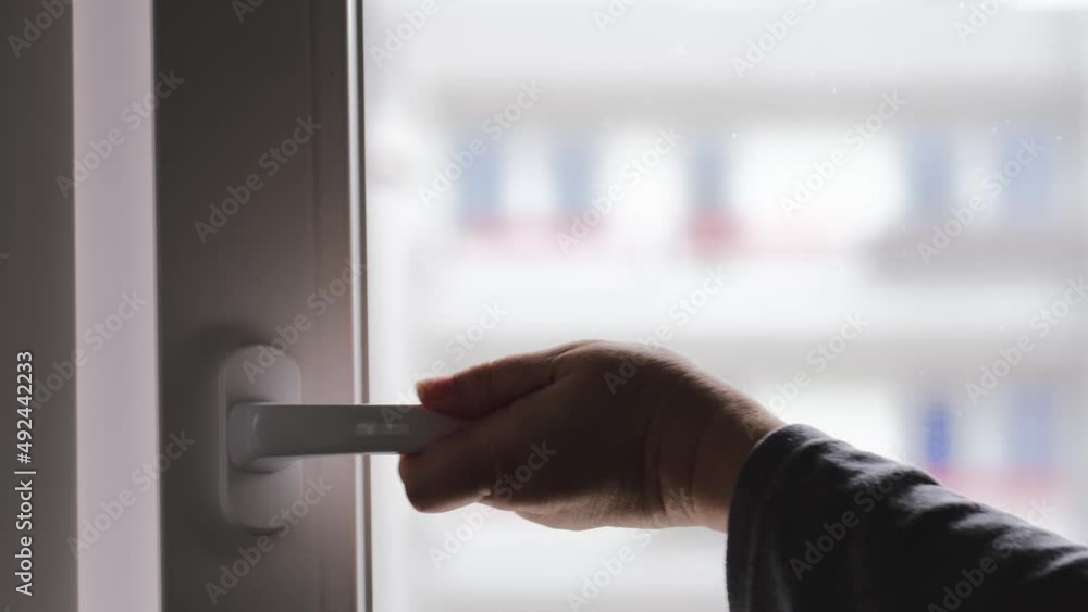 close-up of female hand behind plastic handle opens new modern window ...