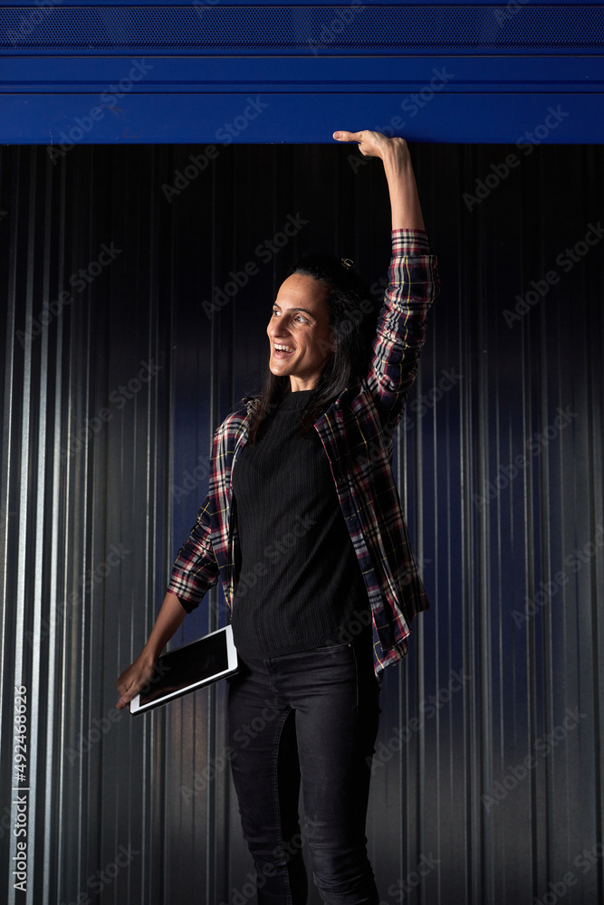 Joyful woman opening roll up door Stock Photo | Adobe Stock