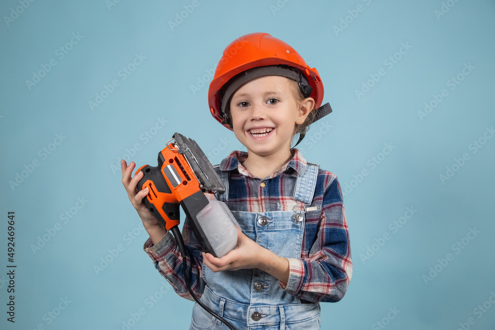 Cute little caucasian kid in orange safety helmet,holding electric ...