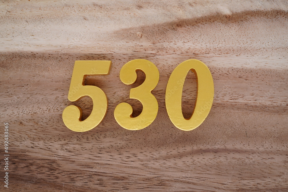 Golden Arabic numerals on a real brown and white wooden floor number ...