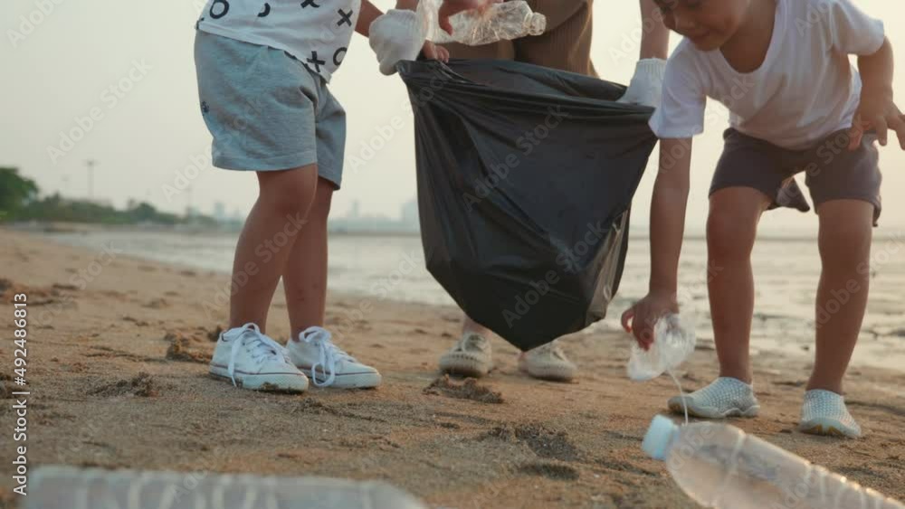 Volunteer happy family picking plastic bottle into trash plastic bag ...