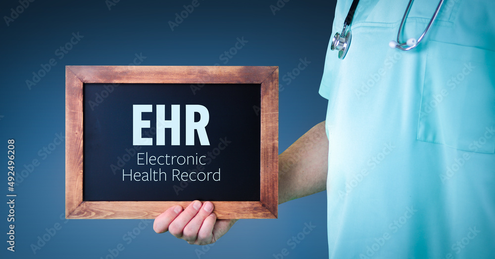 EHR (Electronic Health Record). Doctor shows sign/board with wooden ...