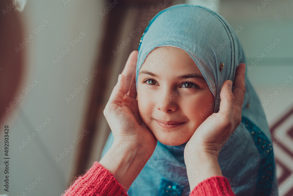 Happy Muslim family. Mother holding her lovely child daughter in hand ...