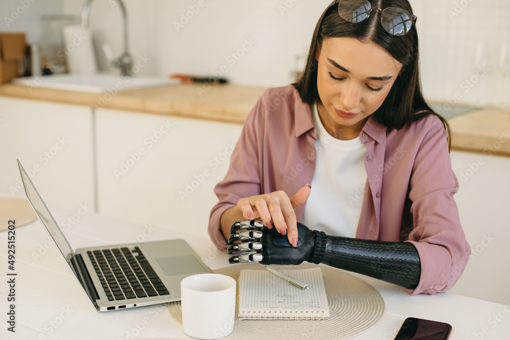 Good-looking stylish young girl adjusting settings of her metal bionic ...