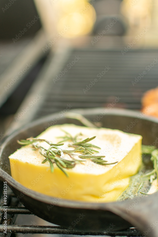 mantequilla derretida con romero en sarten de hierro sobre la parrilla ...