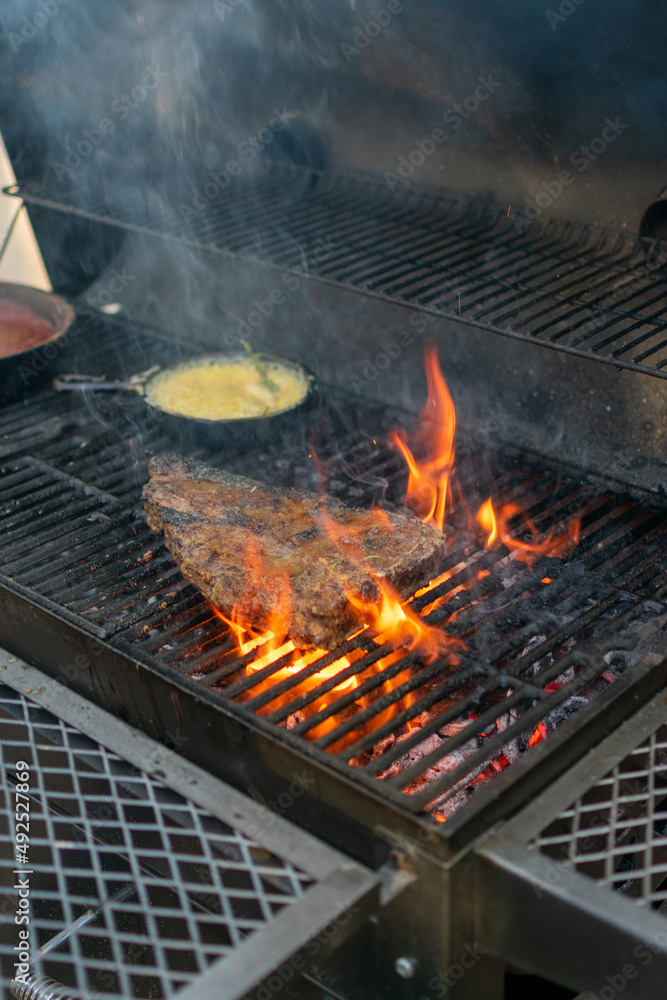 corte de res T- bone. T bone corte en el asador corte al carbón manos ...