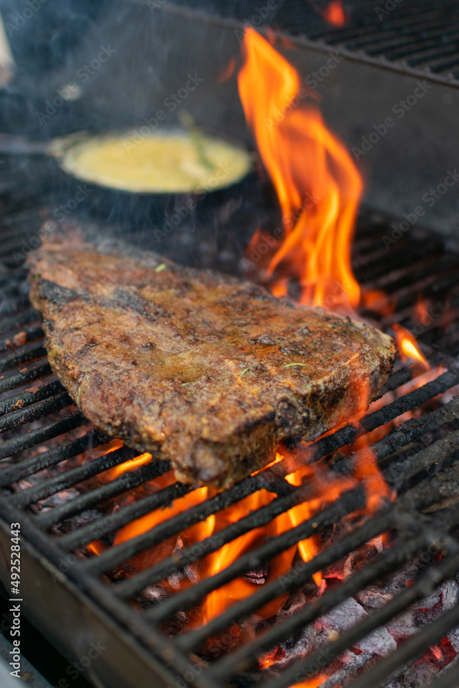 corte de res T- bone. T bone corte en el asador corte al carbón manos ...