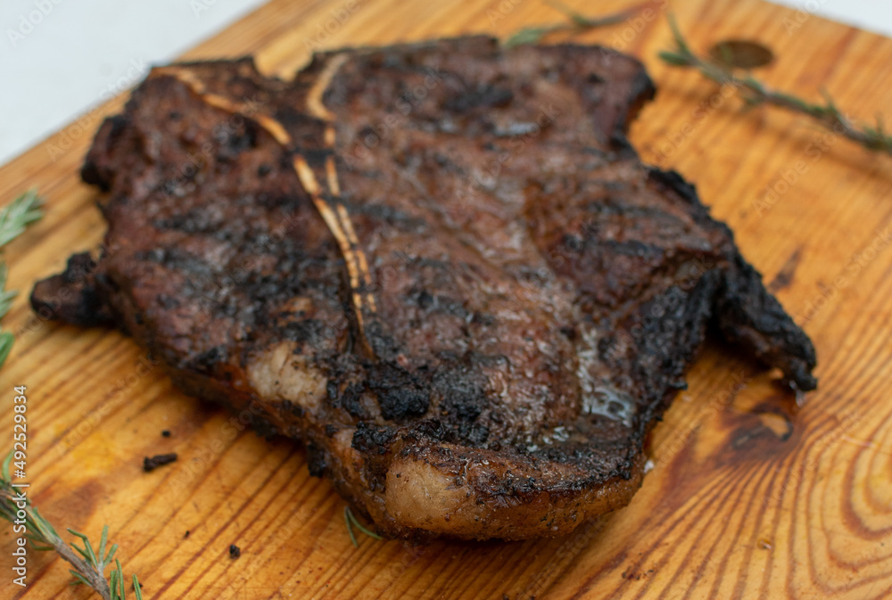corte de res T- bone. T bone corte en el asador corte al carbón manos ...
