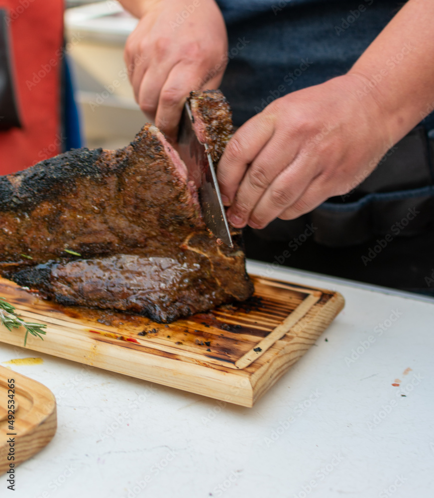 corte de res T- bone. T bone corte en el asador corte al carbón manos ...