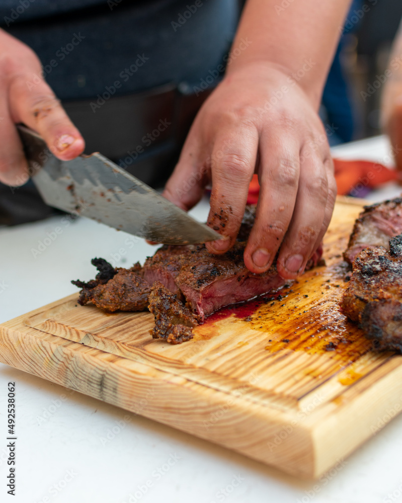 corte de res T- bone. T bone corte en el asador corte al carbón manos ...