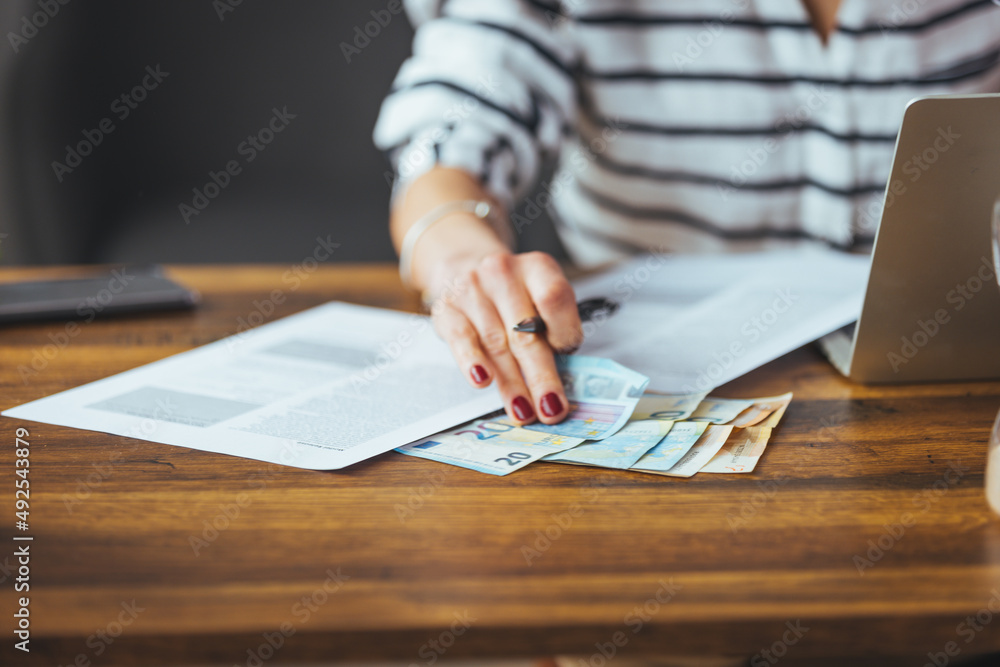 A business woman who pays her bills online at home using a laptop ...
