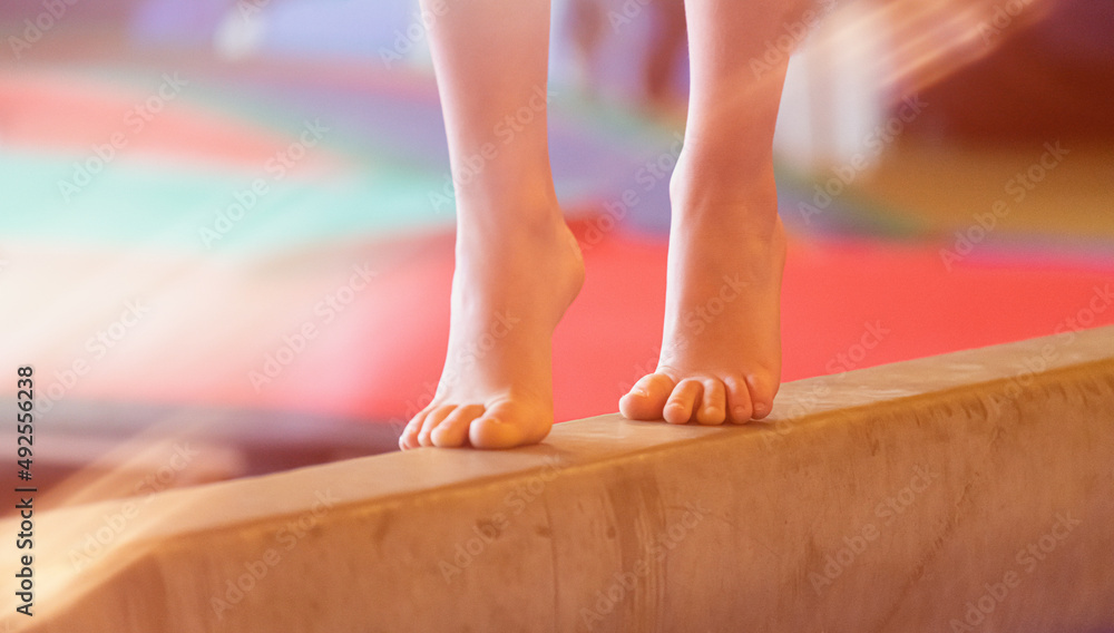 Young female barefoot on balance beam gymnastic balance practicing ...