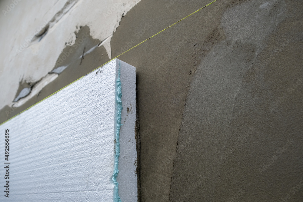 Installation of styrofoam insulation sheets on house facade wall for ...
