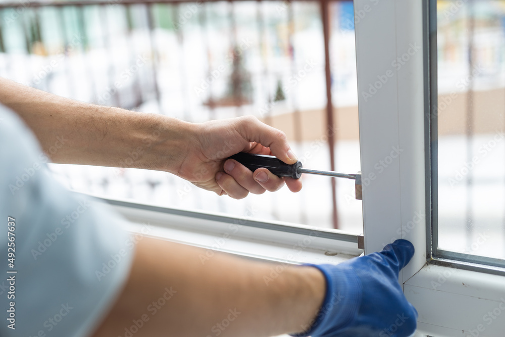 Construction worker installing window in house. Handyman fixing the ...