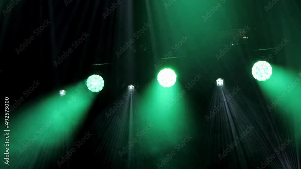 Looking up at green led stage lights as they shine through fog at ...