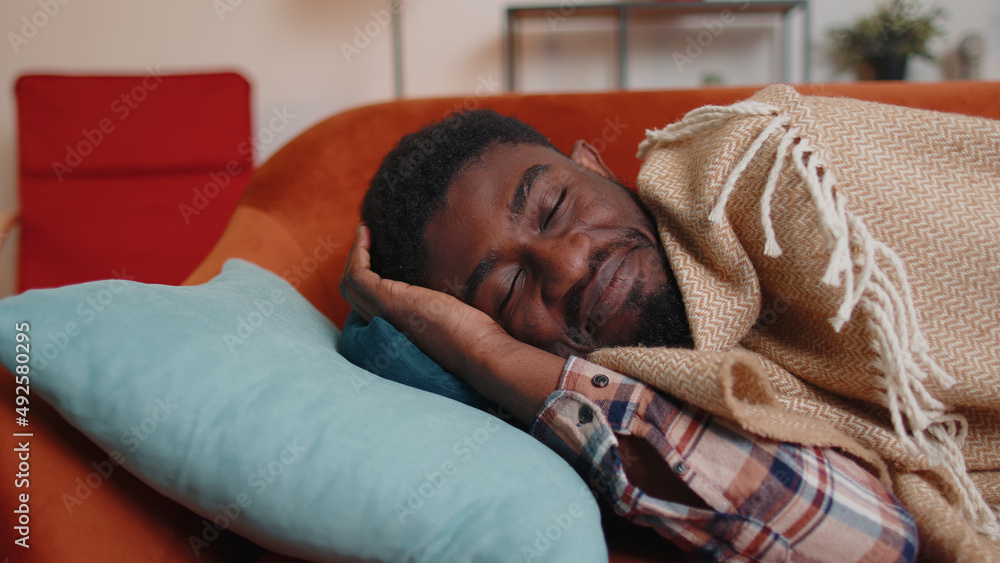 Portrait of african american young man sleeping quietly in bedroom at ...