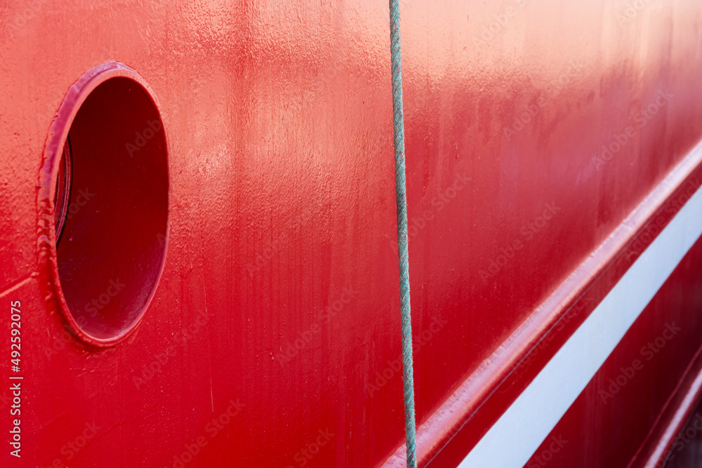 Ship porthole and string of boat. Red and white ship's hull. Seaport ...