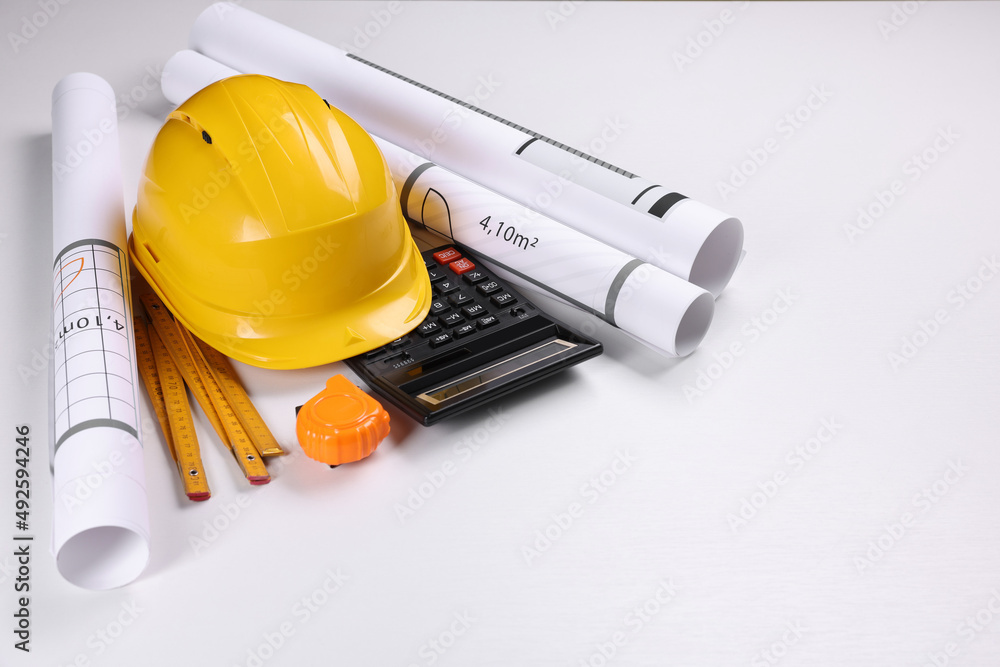 Construction drawings, safety hat, calculator, tape measure and folding ...