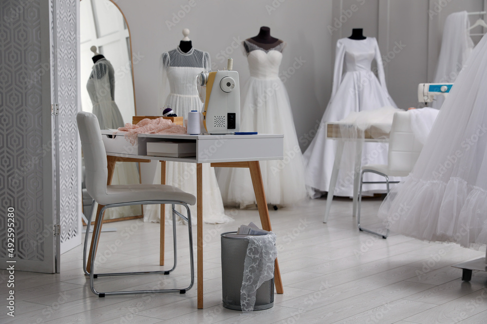 Dressmaking workshop interior with wedding dresses and equipment Stock ...