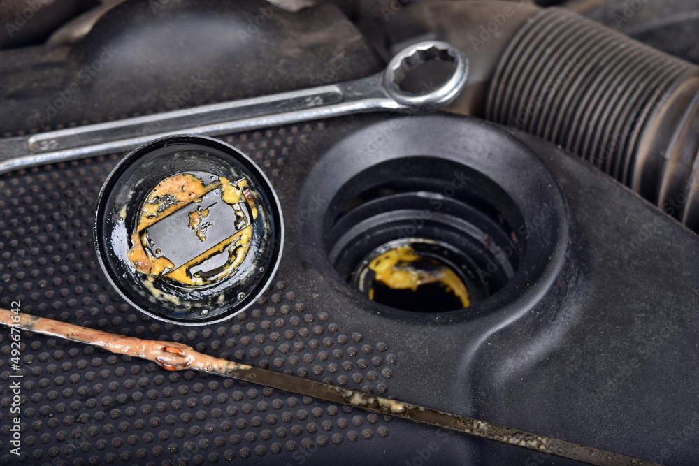 The thick, greasy yellow motor oil under oil cap as signs and symptom ...