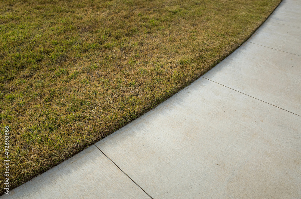 A curved concrete pedestrian footpath with a perfect lawn edge. Concept ...