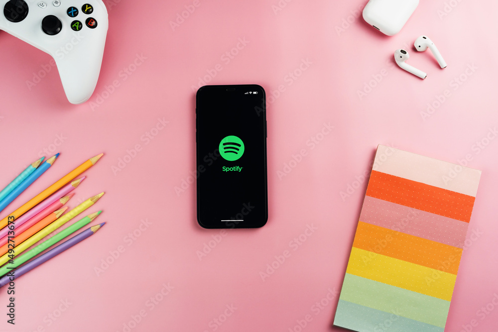 Spotify Music app on the smartphone screen. Pink background with school ...