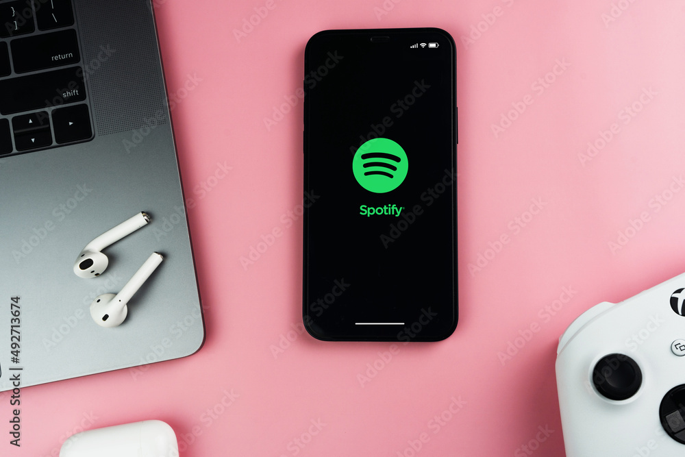 Spotify Music app on the smartphone screen. Pink background with ...