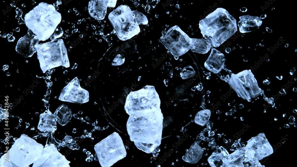Super slow motion of rotating ice cubes with splashing water, top view ...
