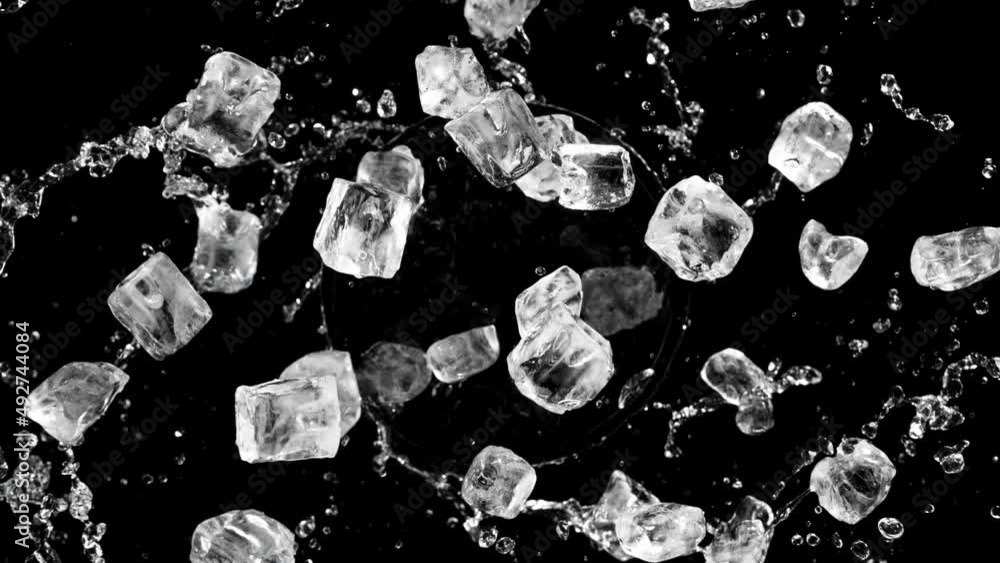 Super slow motion of rotating ice cubes with splashing water, top view ...