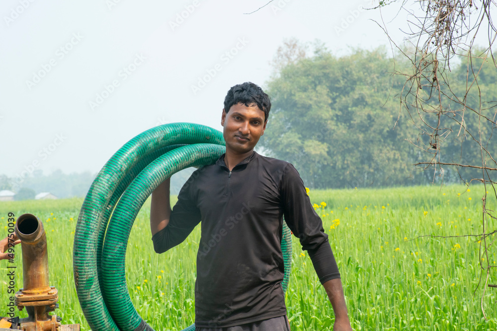 Indian farmer with water pump Stock Photo | Adobe Stock