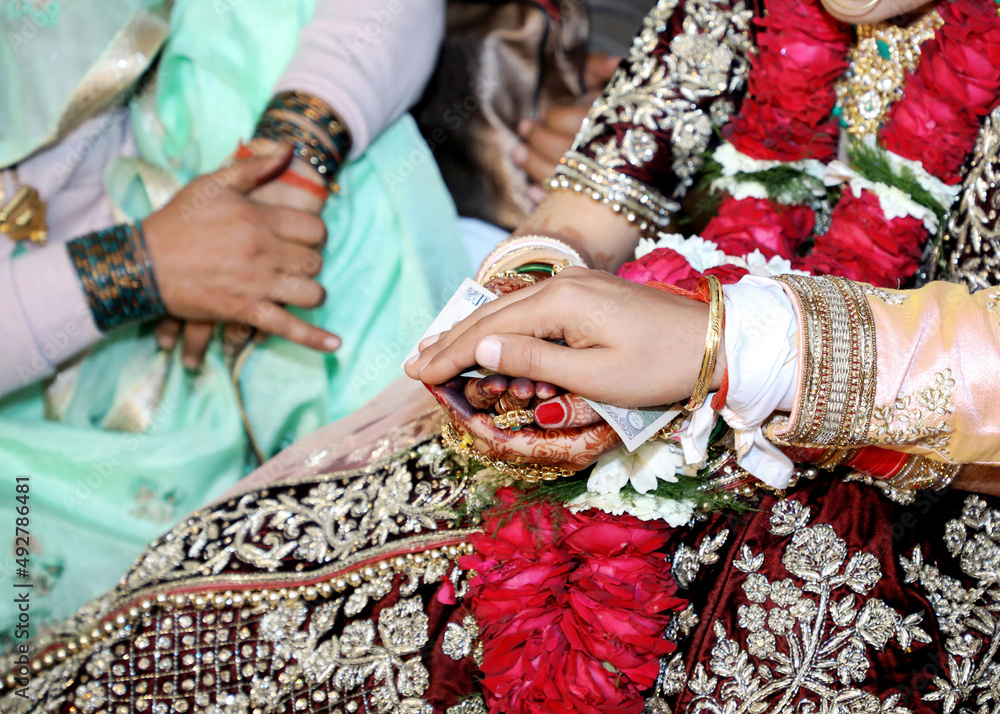 Hand of the bride held by a groom during a traditional ritual in an ...
