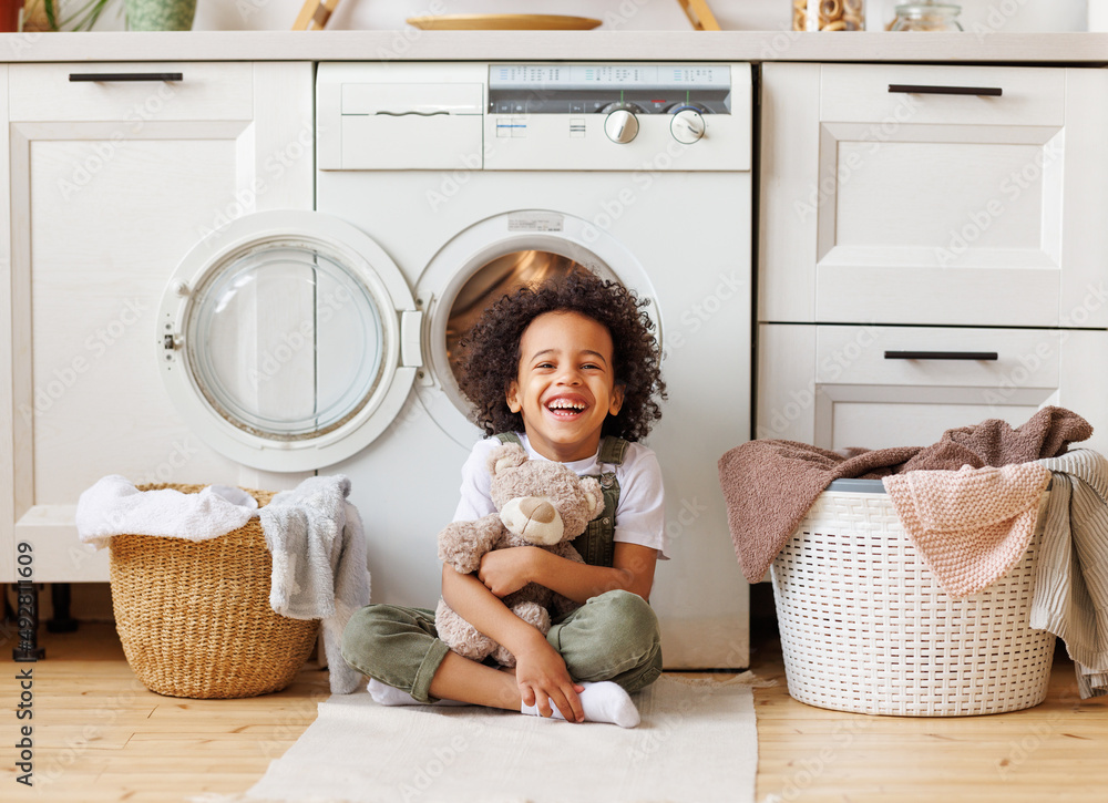 Happy laughing child loading washing machine Stock Photo | Adobe Stock