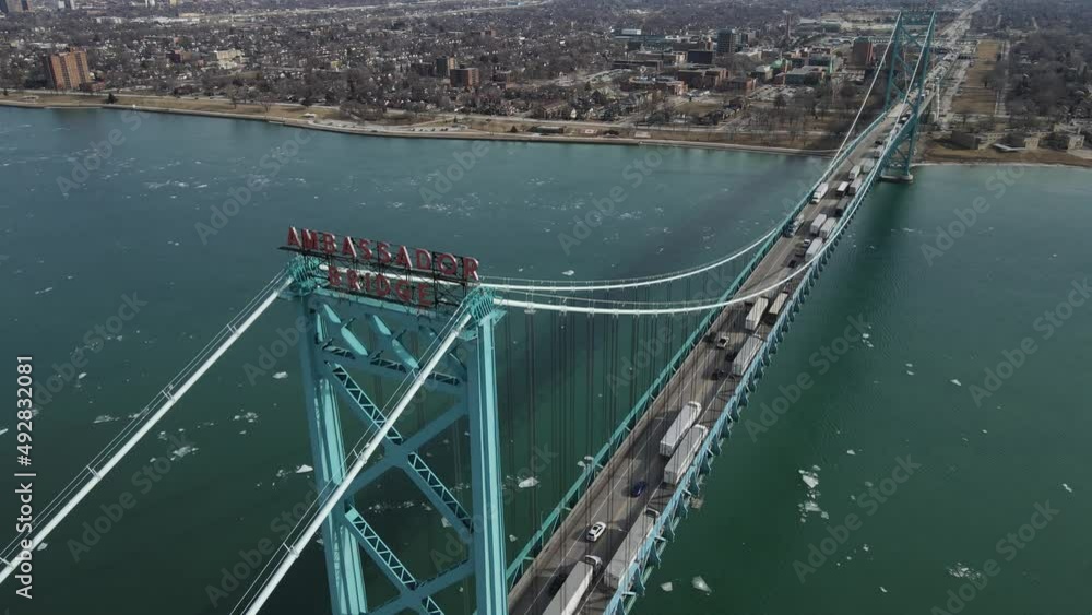 Ambassador bridge over Detroit river with long line of semi-trucks ...