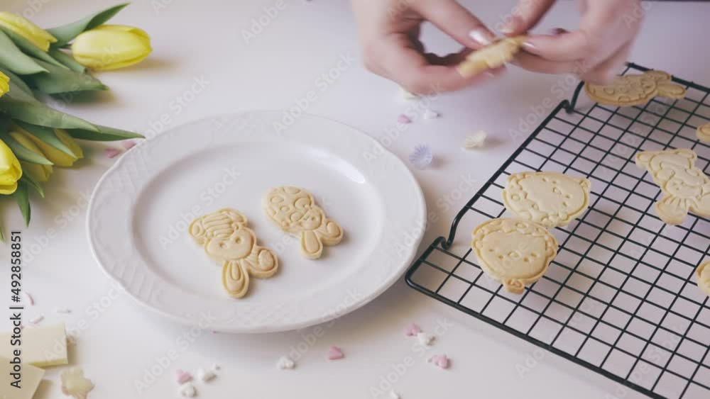 Vidéo Stock Female transfer fresh baked Easter cookies from cooling ...