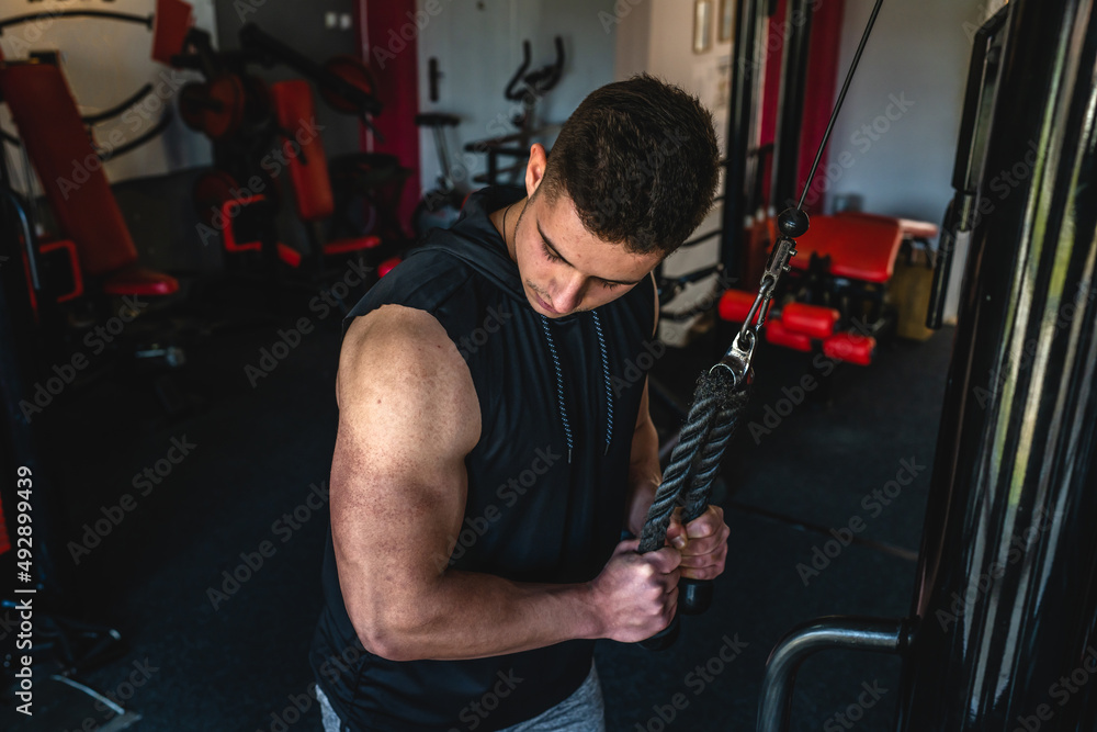 One man side view caucasian male bodybuilder at gym wearing black shirt ...