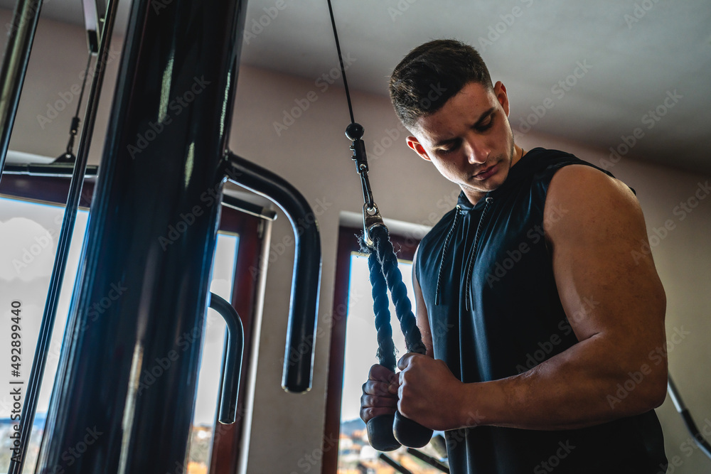 One man side view caucasian male bodybuilder at gym wearing black shirt ...