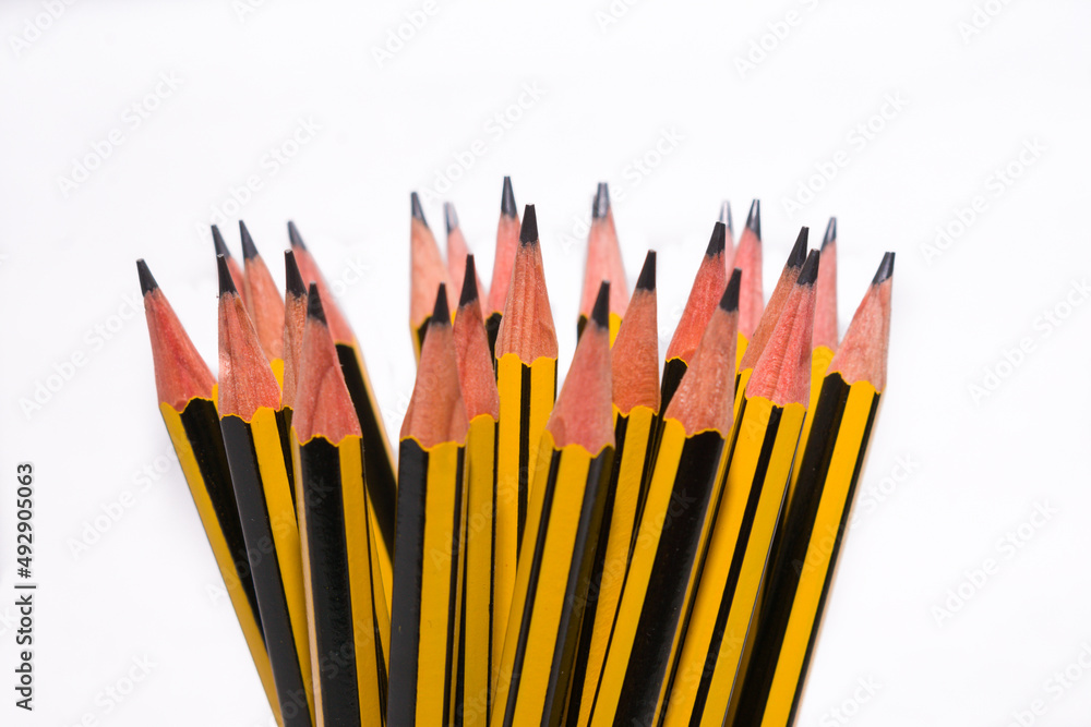 Graphite pencil with yellow and black external surface surrounded by ...